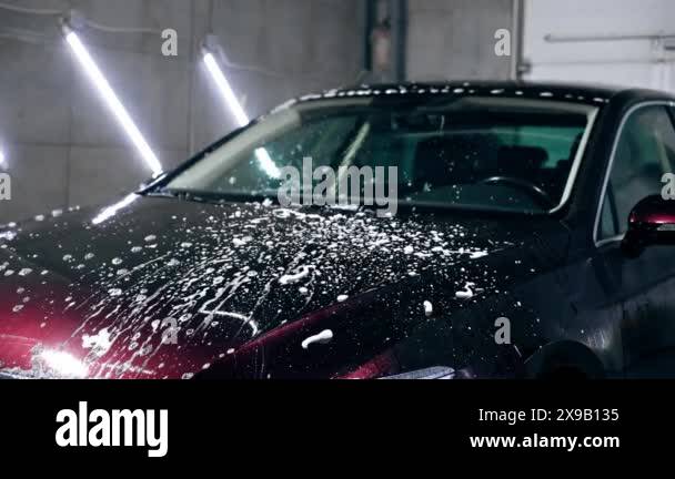 at service station in a car wash booth the process of soaping a car ...