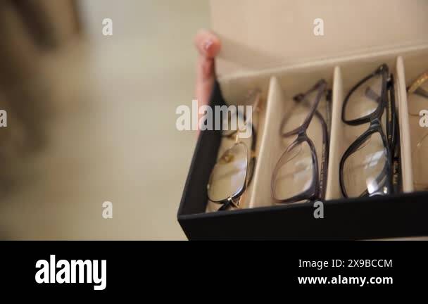 People are depicted in a video holding boxes of different glasses, with ...