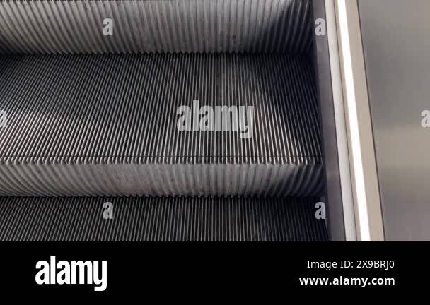 Vertical close-up photograph of moving escalator steps showing the ...