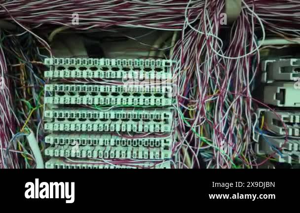 Inside a PABX telephone booth that has a number of connecting cables in ...