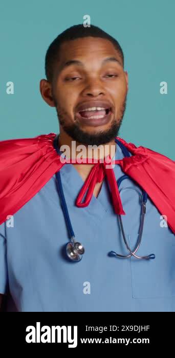 Vertical video Male nurse portraying superhero showing courage and ...