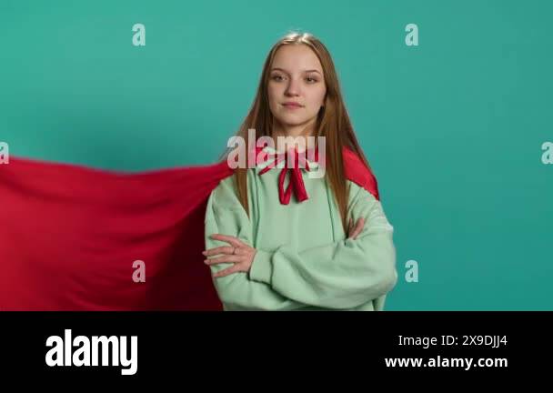 Happy young girl portraying superhero flying with cape fluttering in ...