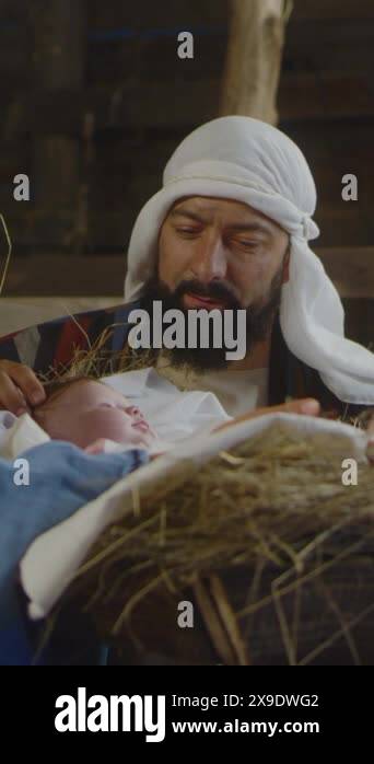 Virgin Mary and Joseph admiring and touching baby Jesus in manger on ...