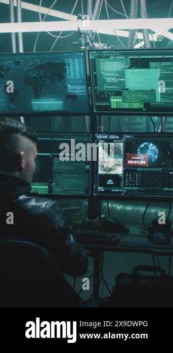 A male hacker in a casual jacket on a chair, hacking a nuclear weapon ...
