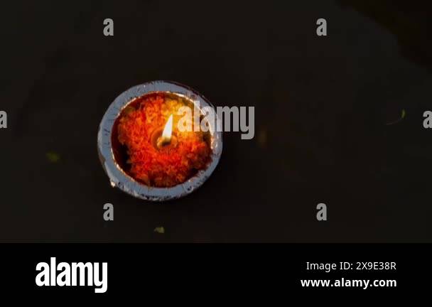Ganga aarti, Fire flame along with rose and marigold flower floating in ...
