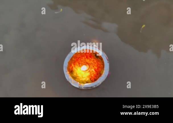 Ganga aarti, Fire flame along with rose and marigold flower floating in ...