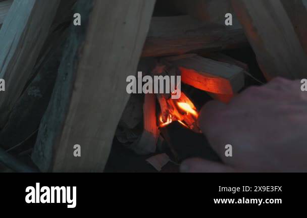 Step-by-step guide on lighting a campfire using kindling and lighter ...