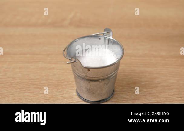 Salt is poured into a small metal bucket. Abuse of salt. Slow motion ...