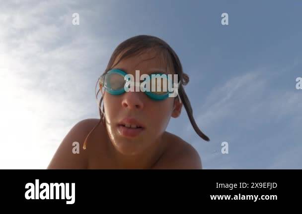 Captured in slow motion, a teenage boy lies on his stomach as he slides ...