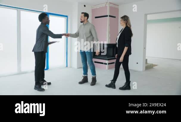 African real estate agent holds the contract in his hands, a wide smile ...