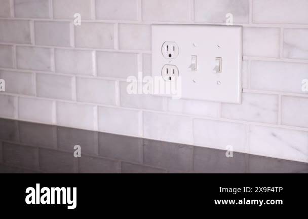 inserting a plug into a wall socket outlet and plugging in a power cord ...