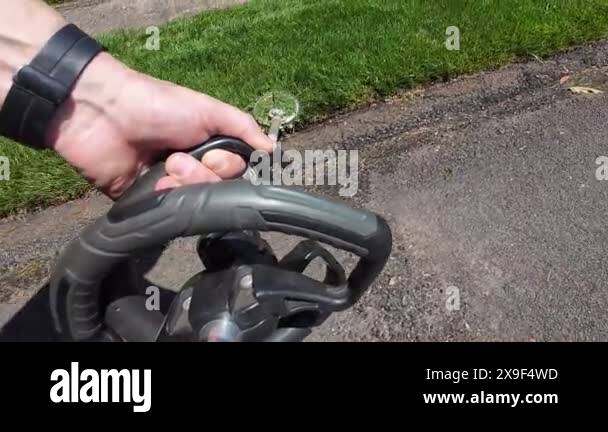 Weed trimmer with rotary scissor attachment trimming grass along curb ...