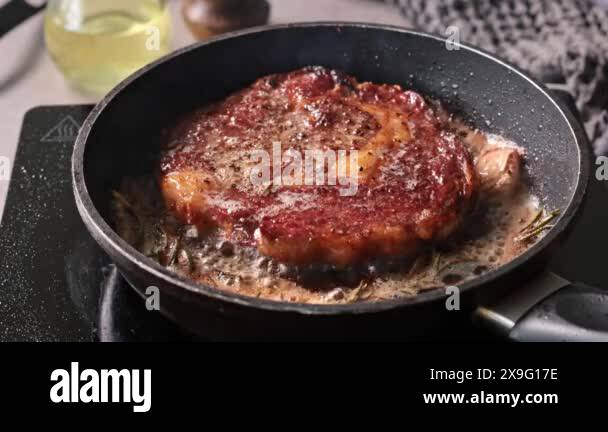 delicious juicy beef steak meat cooking on a pan with garlic and ...