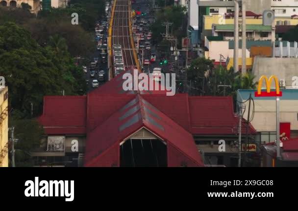 Elevated train line above a busy street in Manila. Vehicles and ...