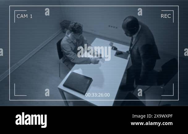 Surveillance camera shot of African American male police officer bringing in murder suspect in ...