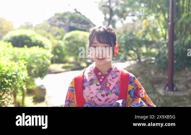 A young woman in her twenties, wearing traditional Ryusou, strolls ...