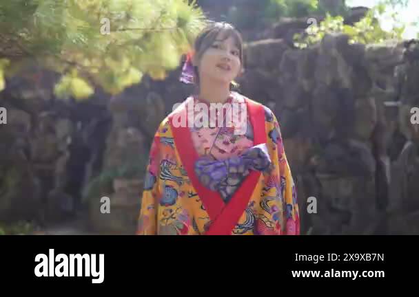 A young woman in her twenties, wearing traditional Ryusou, strolls ...