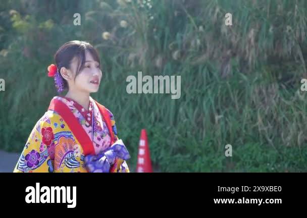 A young woman in her twenties, wearing traditional Ryusou, is walking ...