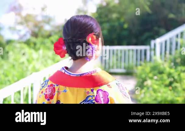 A young woman in her twenties, wearing traditional Ryusou, is walking ...