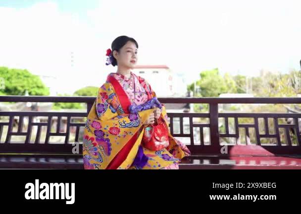 A young woman in her twenties, wearing traditional Ryusou, sits ...