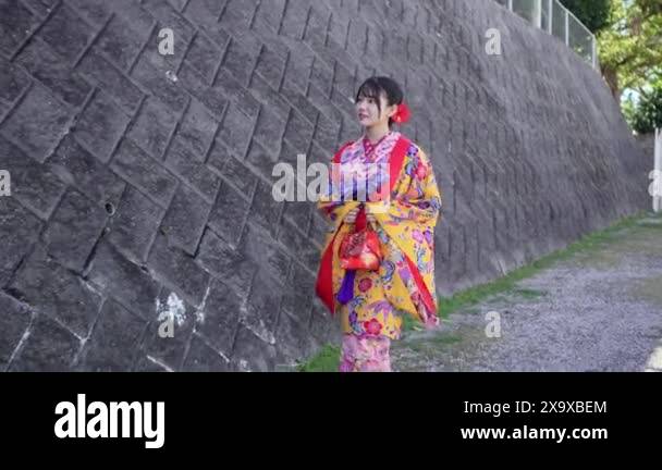 A young woman in her twenties, wearing traditional Ryusou, is walking ...