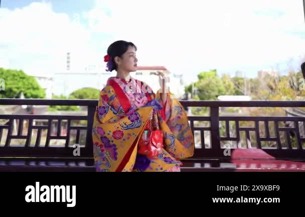 A young woman in her twenties, wearing traditional Ryusou, sits ...