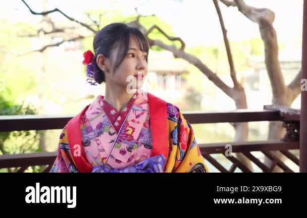A young woman in her twenties, wearing traditional Ryusou, sits ...