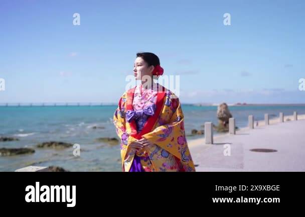 A young woman in her twenties, wearing traditional Ryusou, walks down a ...