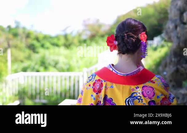 A young woman in her twenties, wearing traditional Ryusou, is walking ...
