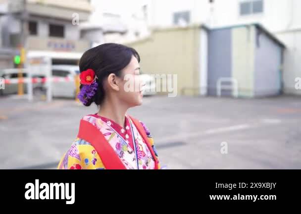 A young woman in her twenties, wearing traditional Ryusou, walks down a ...