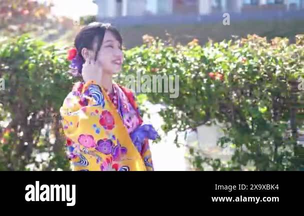 A young woman in her twenties, wearing traditional Ryusou, is walking ...