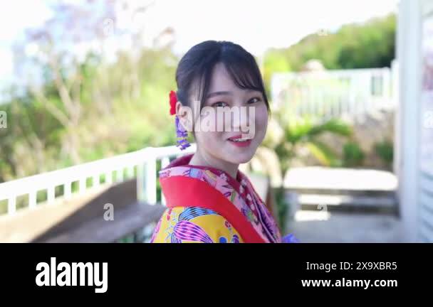 A young woman in her twenties, wearing traditional Ryusou, is walking ...