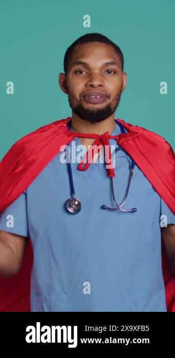 Vertical video Male nurse portraying superhero showing courage and ...