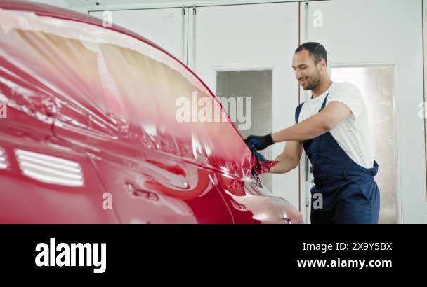 Automotive Paint Technician Inspecting Red Car in Spray Booth. Male car ...
