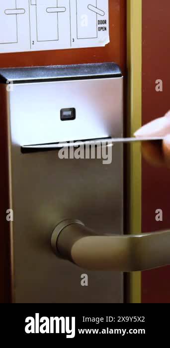 A young woman opens the door of his hotel room using an electronic key ...