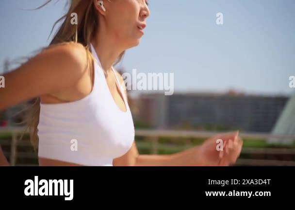 Asian oriental adult woman jogger in sportswear running workout sunny morning urban high tech ...