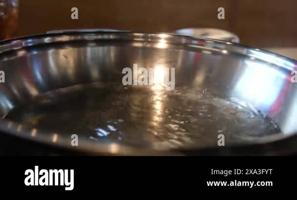 Pot of boiling water over black background. Bubbles of boiling water ...