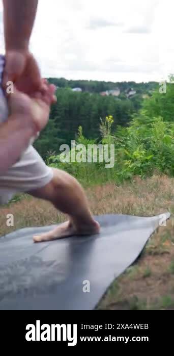 Concentrated man and woman stand in yoga asana holding hands behind ...