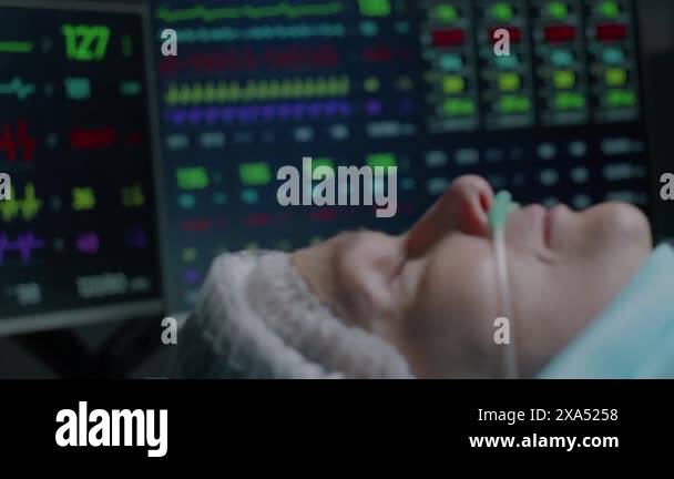 Closeup of female patient with oxygen nasal tube awakening from ...