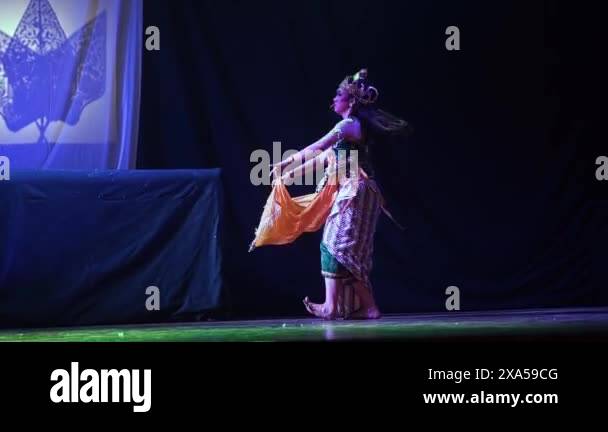 Two dancers in traditional attire performing a cultural dance on stage ...