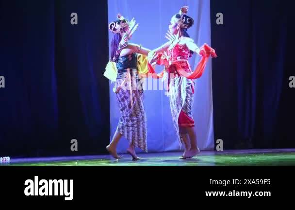 Two women in traditional Indonesian dance costumes performing on stage ...