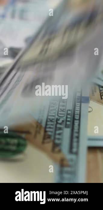 Hundred dollar bills falling on spinning table in a pile of cash. A ...