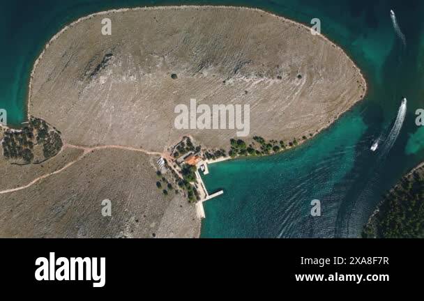 Drone view directly from above on island of Kornati archipelago with small houses and pier for ...