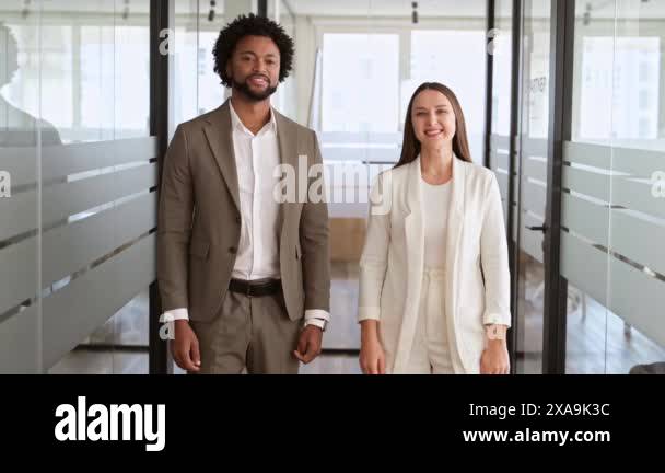 Standing confidently in a sleek office environment, a young businessman ...