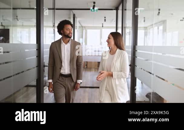 In a modern office corridor, an African-American businessman and his ...