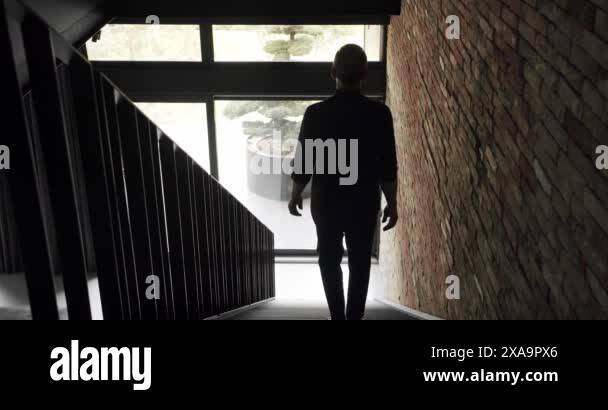 The man descends the stairs in the house from the second floor in the ...