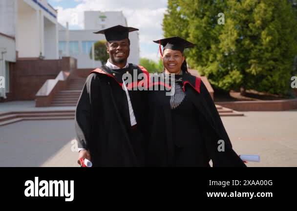 Happy african american couple students graduates in graduation gowns ...