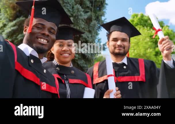Three happy multiracial diverse students in graduation gowns making ...