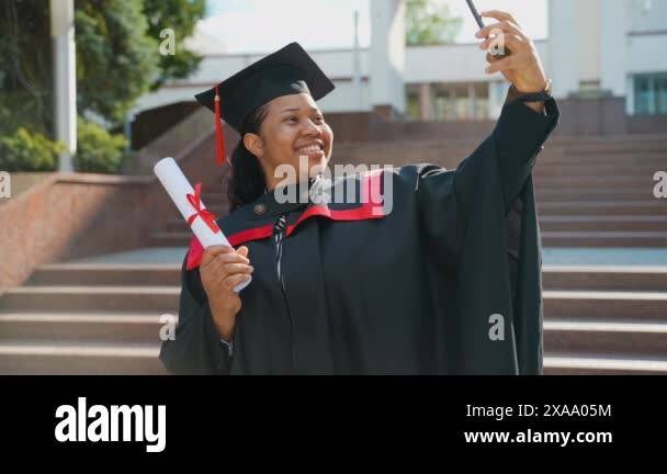 Female student graduate on video call shows parents a diploma ...