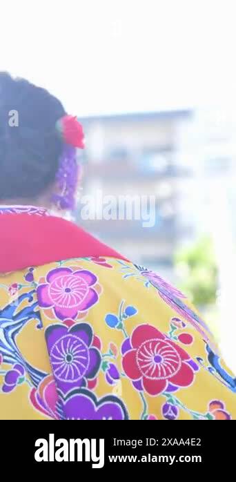 A young woman in her twenties, wearing traditional Ryusou, uses stairs ...